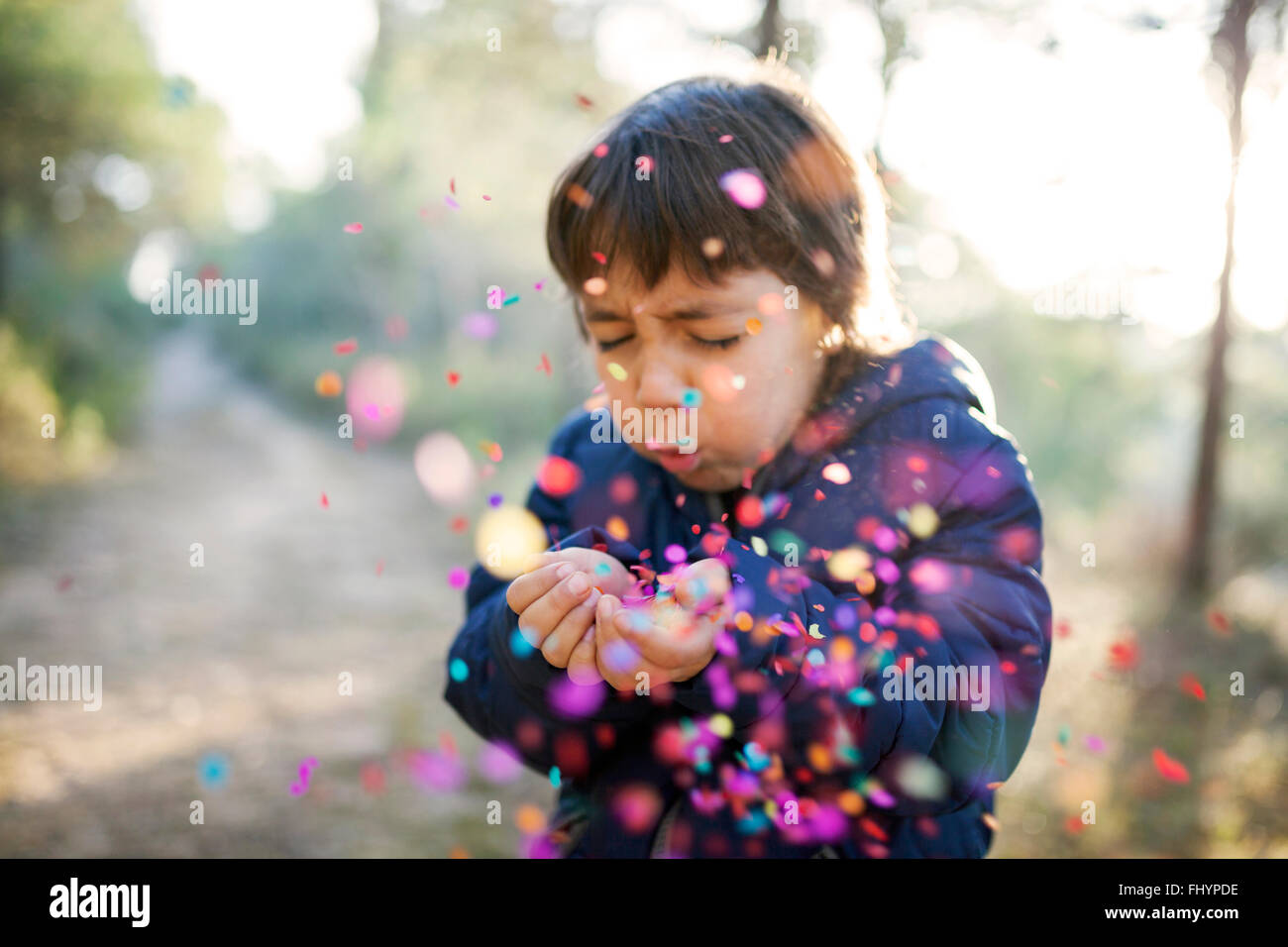 Little boy blowing confetti into the air Stock Photo - Alamy