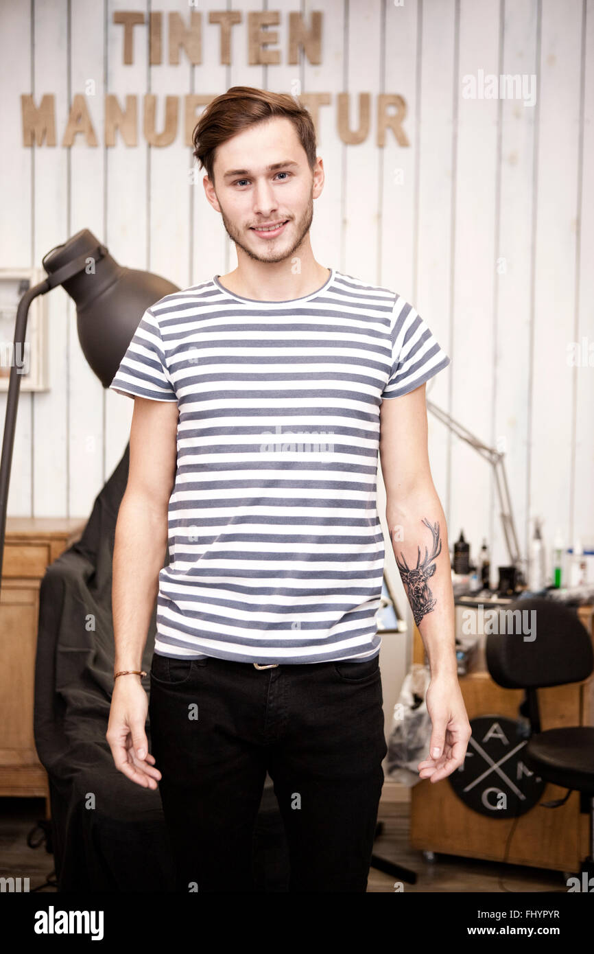 Portrait of happy young man with new tattoo Stock Photo - Alamy