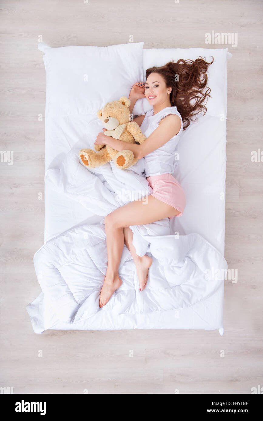 Charming woman lying in bed Stock Photo - Alamy