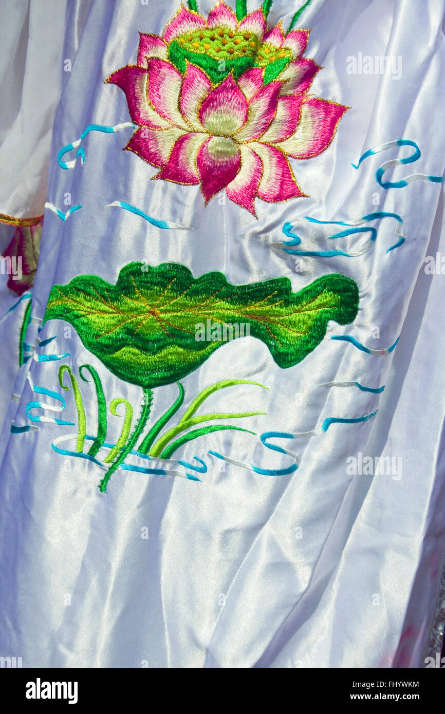 A colorful traditional embroidered Chinese robe is worn by a man at a ...