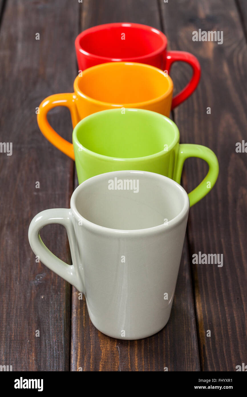 Four color empty tea cups arranged in one row on wood Stock Photo - Alamy