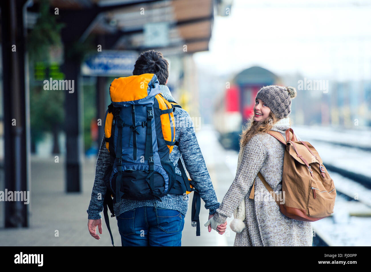 Young couple hand in hand on station platform Stock Photo - Alamy
