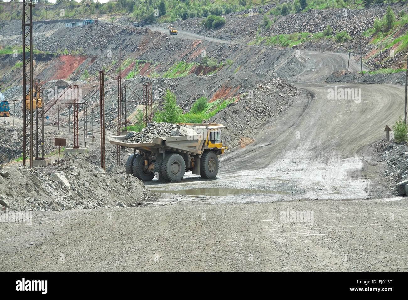 Dump trucks and train delivering iron ore from the opencast Stock Photo ...