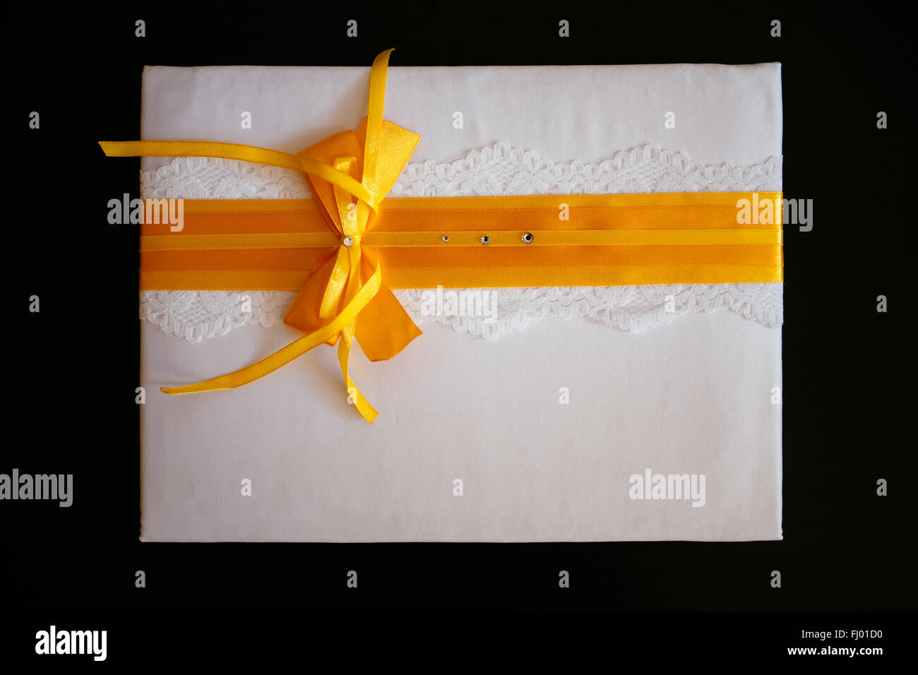 White gift envelope with a yellow ribbon Stock Photo - Alamy