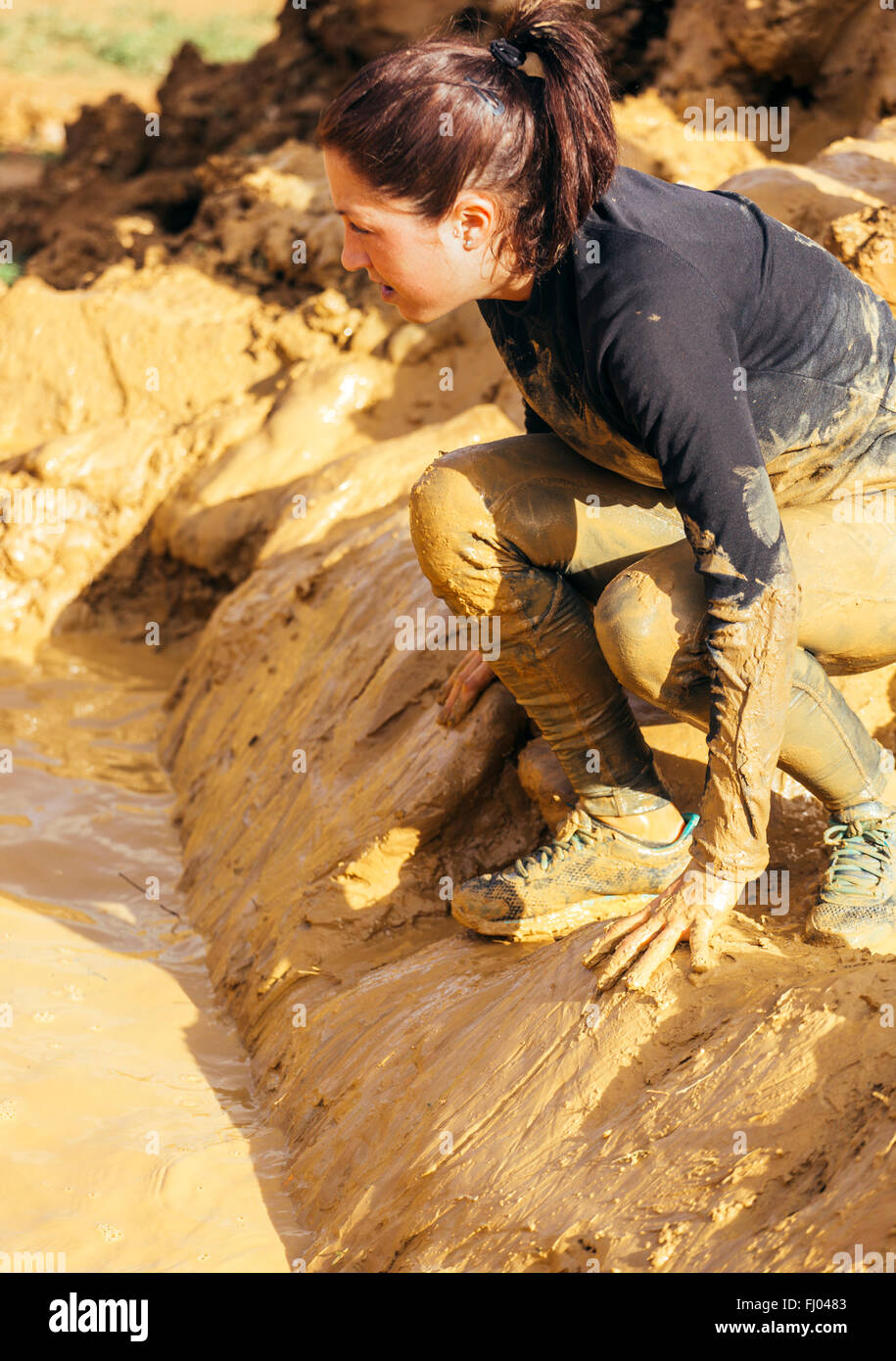 Participants in extreme obstacle race, running through mud Stock Photo ...