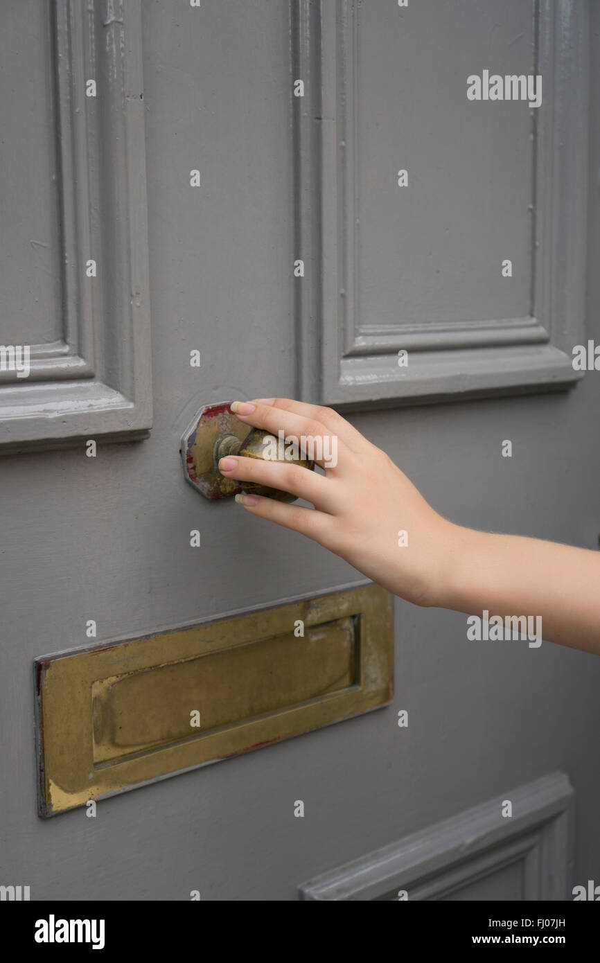 Woman's hand holding a door handle Stock Photo - Alamy