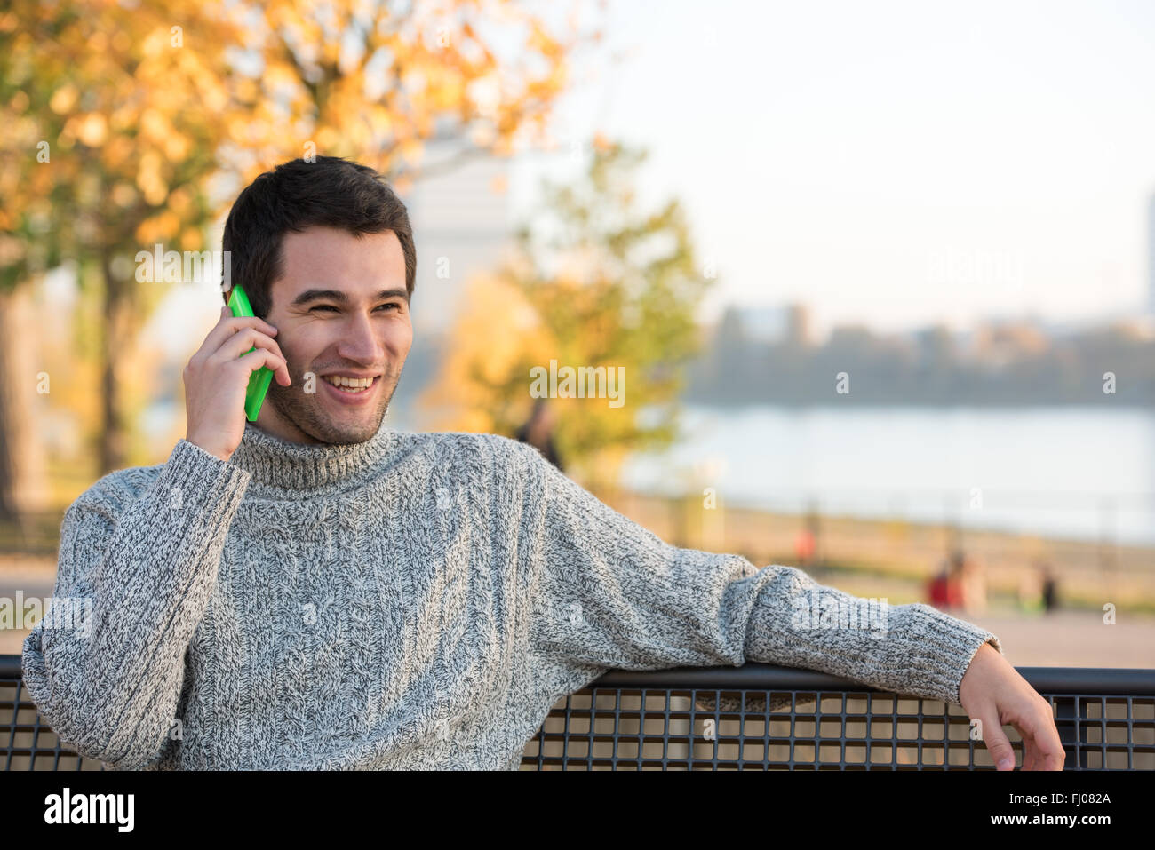 young man in park sitting on bench, speaking on the smart phone Stock ...