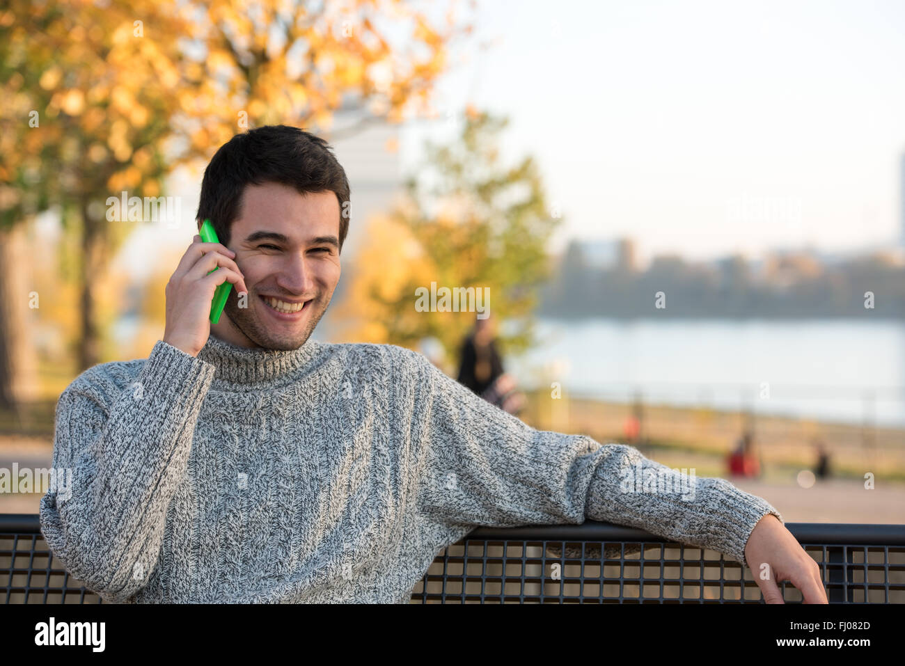 young man in park sitting on bench, speaking on the smart phone Stock ...
