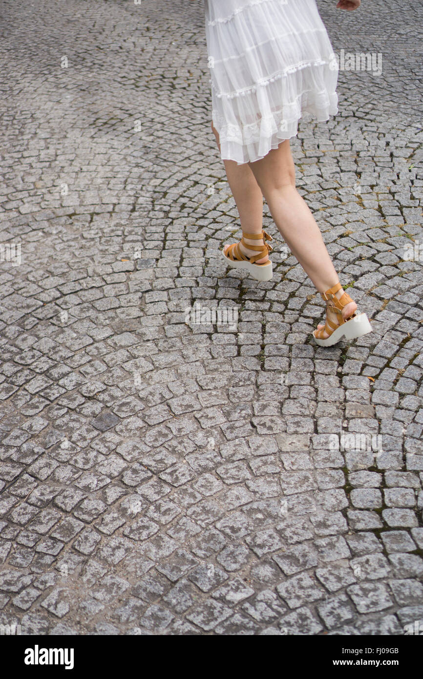 Woman running on cobbled road Stock Photo - Alamy