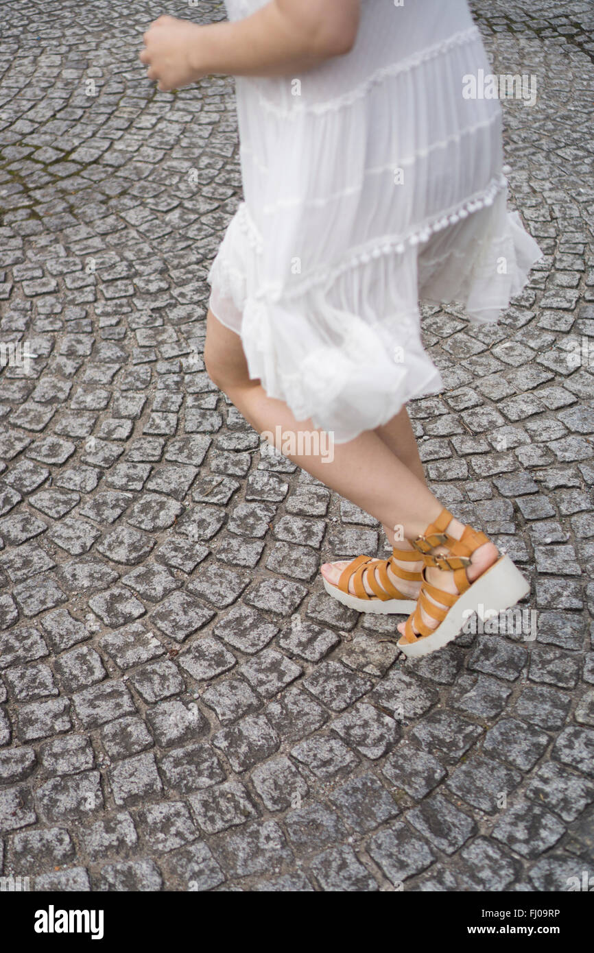 Woman running on cobbled road Stock Photo - Alamy