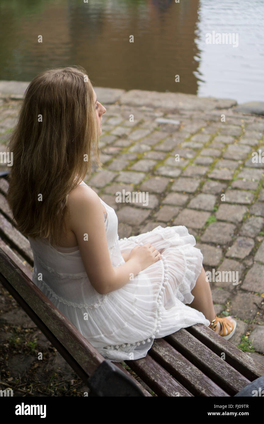 Woman sat on the bench by the canal Stock Photo - Alamy