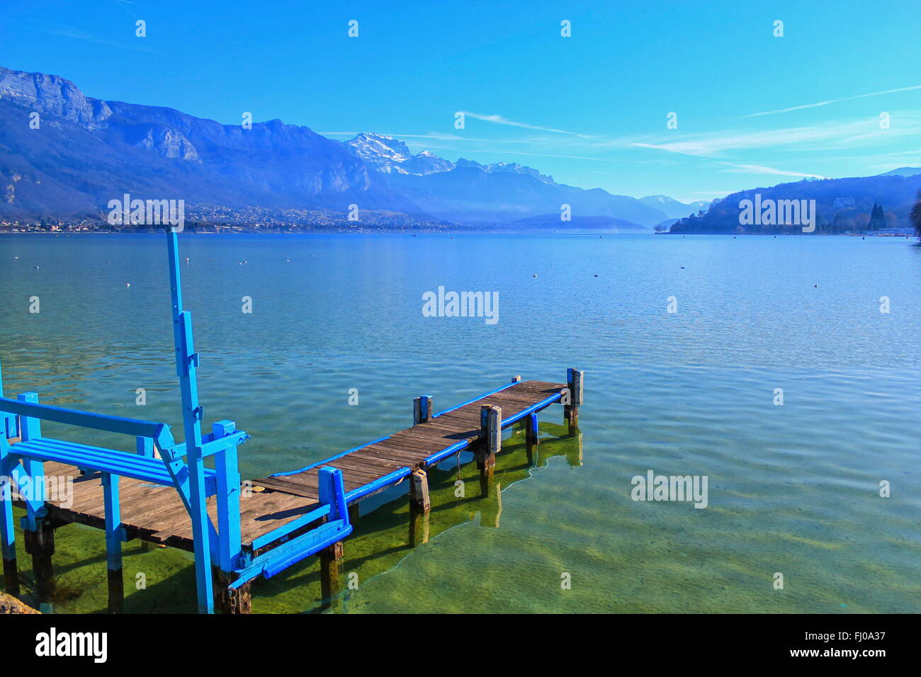 Blue wooden pontoon on Annecy lake and Alps mountains by beautiful day ...