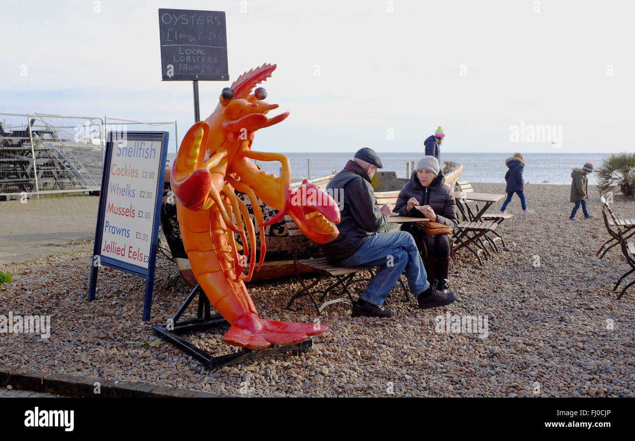 A couple eat shellfish from one of the stalls on Brighton seafront UK ...