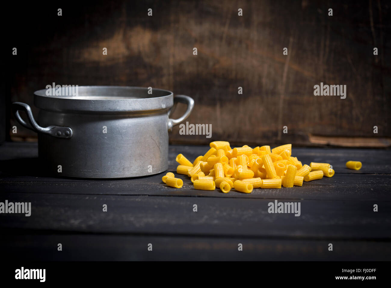 Cooking pot and macaroni on dark wood Stock Photo - Alamy