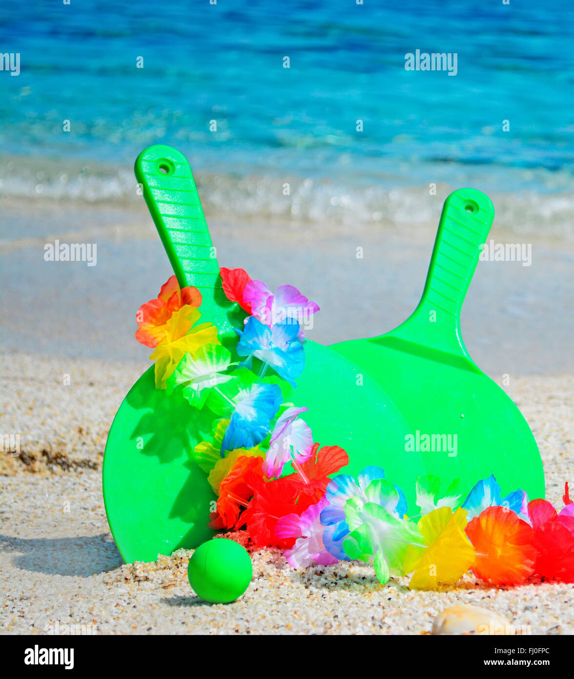 green rackets and necklace on a beach Stock Photo - Alamy