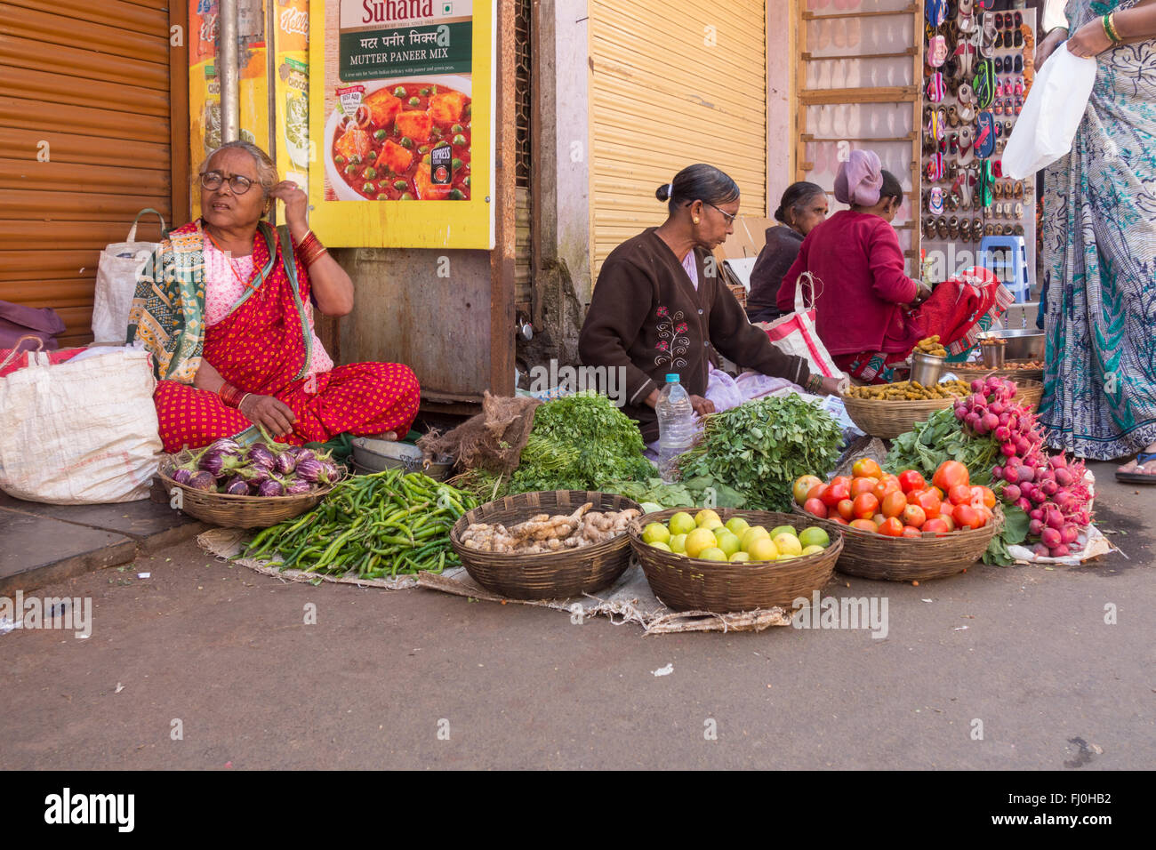 Women traders selling fruit and vegetables at the roadside market in Mahabaleshwar, Maharashtra ...
