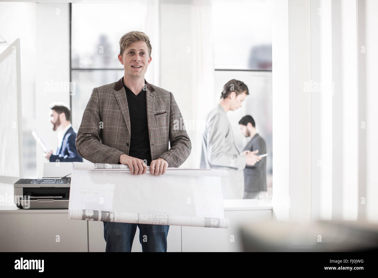 Man in office holding plan Stock Photo - Alamy