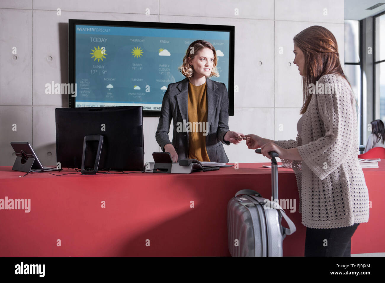 Woman arriving at reception desk Stock Photo - Alamy