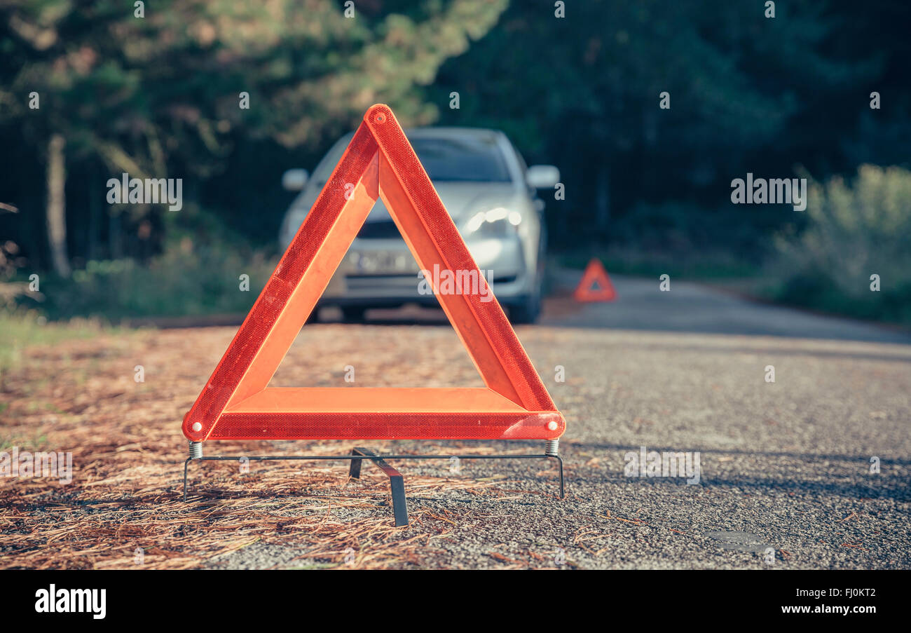 Warning triangle in the road by a car breakdown Stock Photo - Alamy