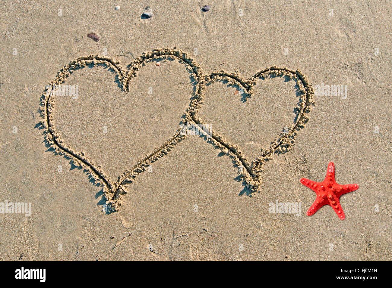 Two hearts drawn sand hi-res stock photography and images - Alamy