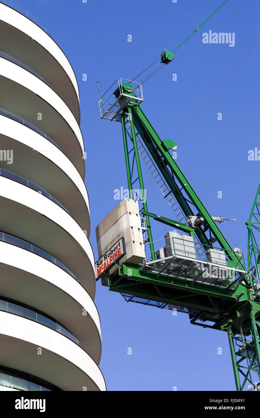 A Crane Lifting Concrete Blocks on to a Tall Building Being Constructed ...