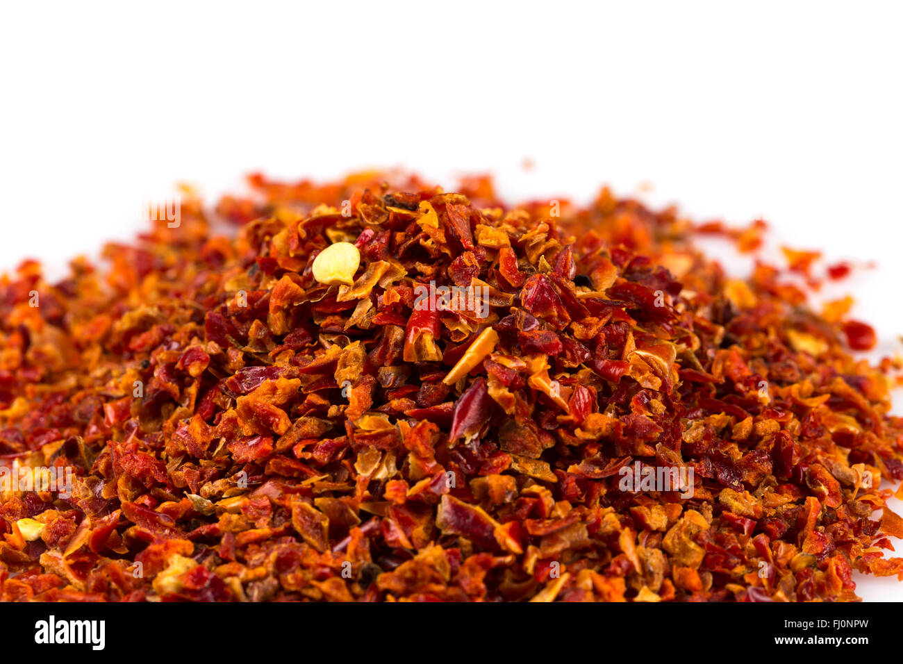 Crushed red chili pepper on white background Stock Photo - Alamy