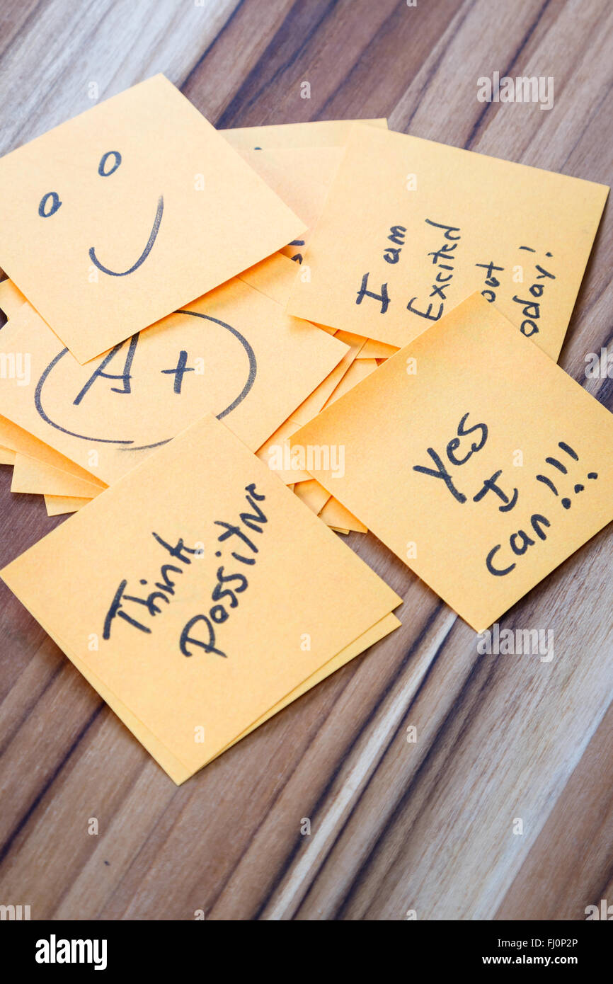 close up of small sticky notes on a wooden desk , all with different ...