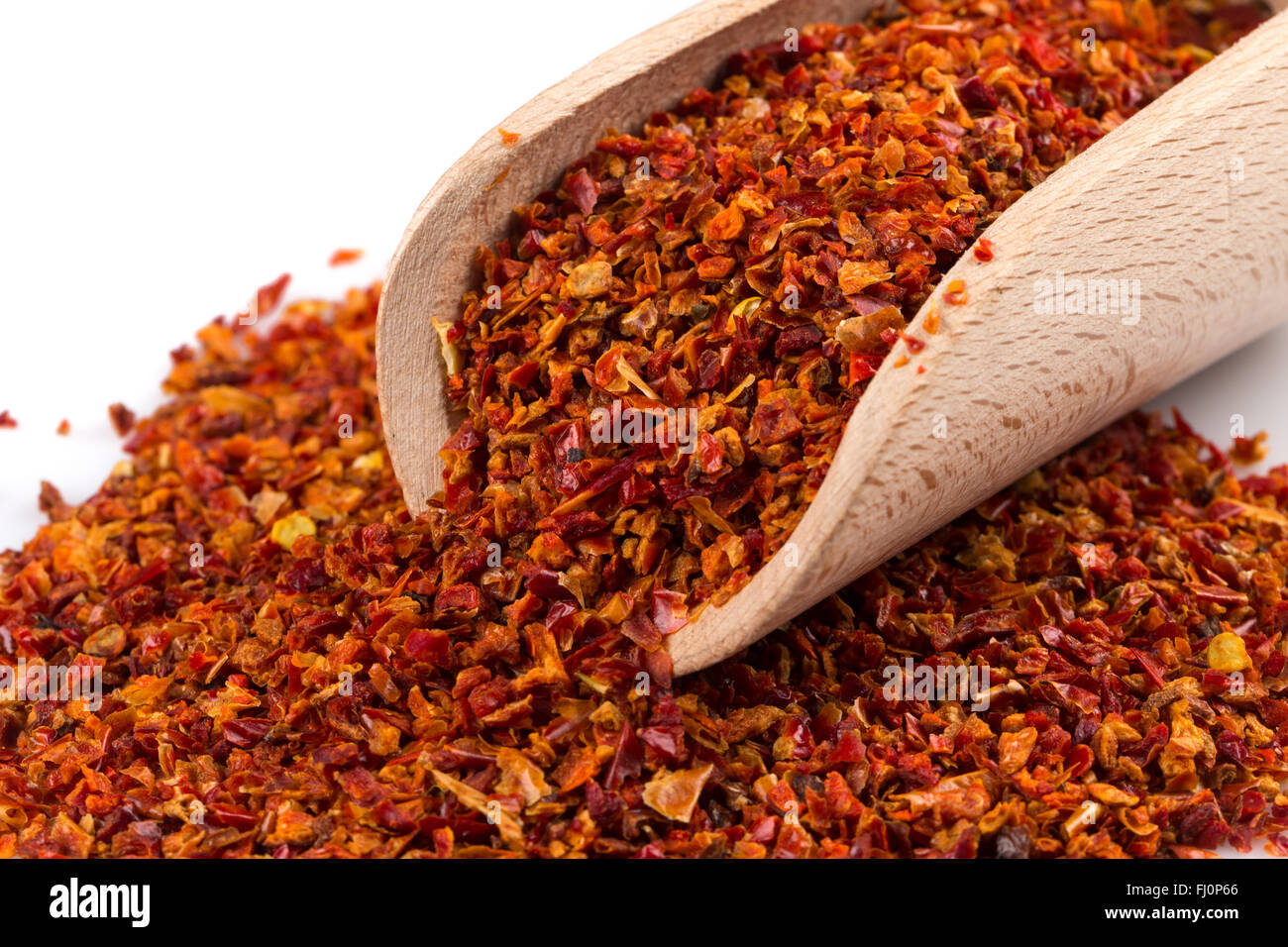 Crushed red chili pepper in spoon on white background Stock Photo - Alamy