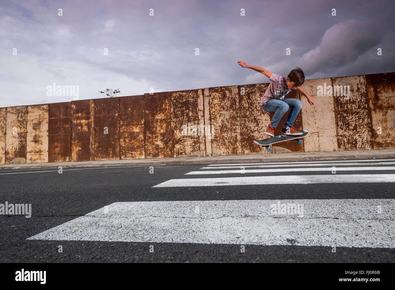 Boy skating on a zebra crossing Stock Photo - Alamy