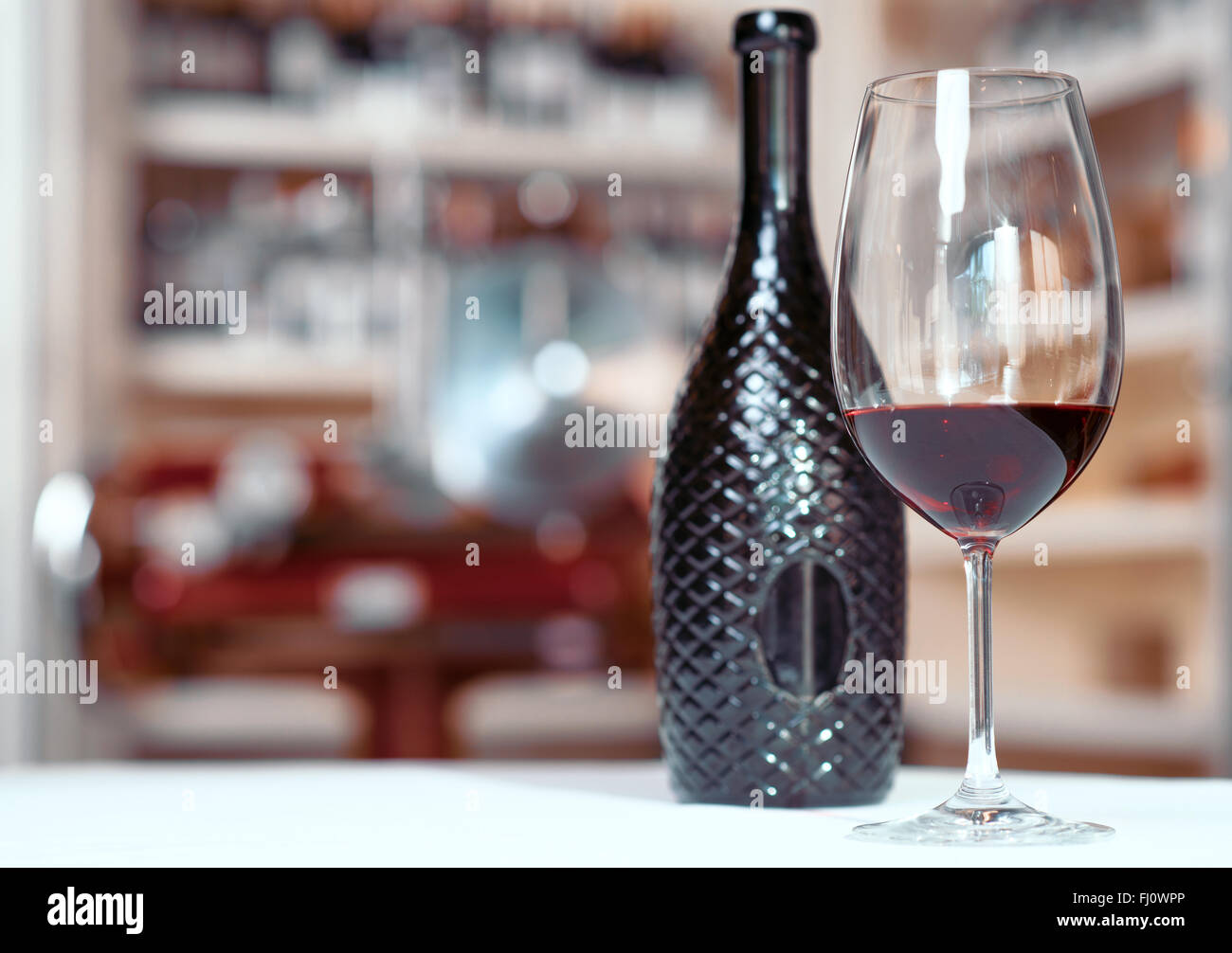 Bottle of wine standing on the table with glass Stock Photo - Alamy