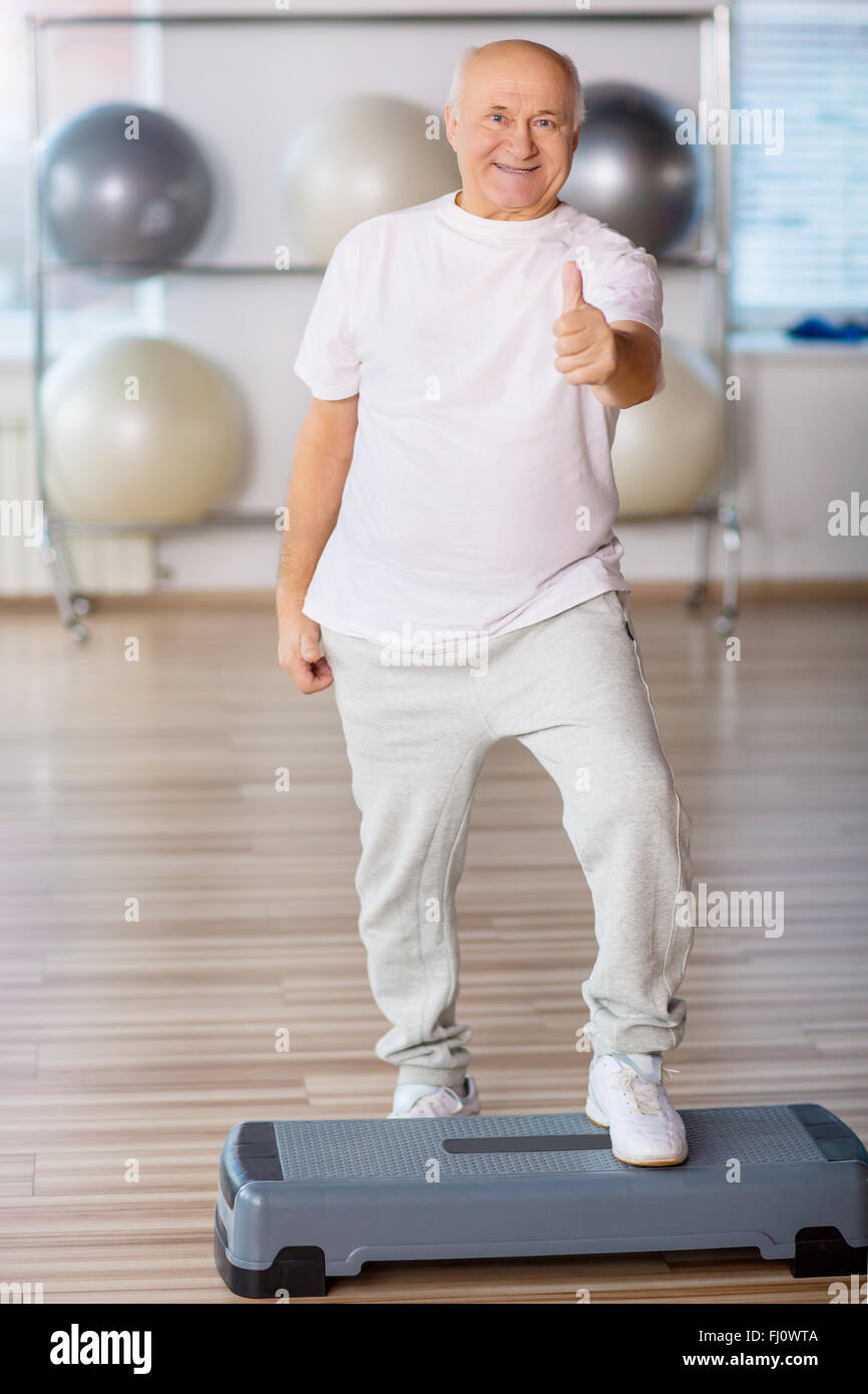 Pleasant senior man practicing step aerobics Stock Photo - Alamy