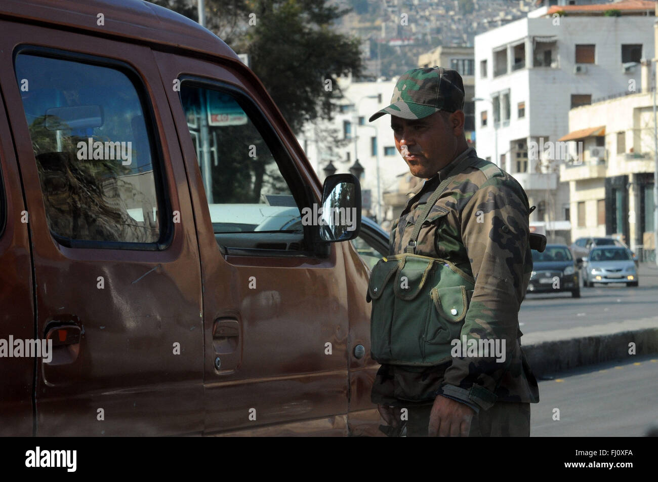 Damascus, Syria. 27th Feb, 2016. A Syrian soldier inspects a car in ...