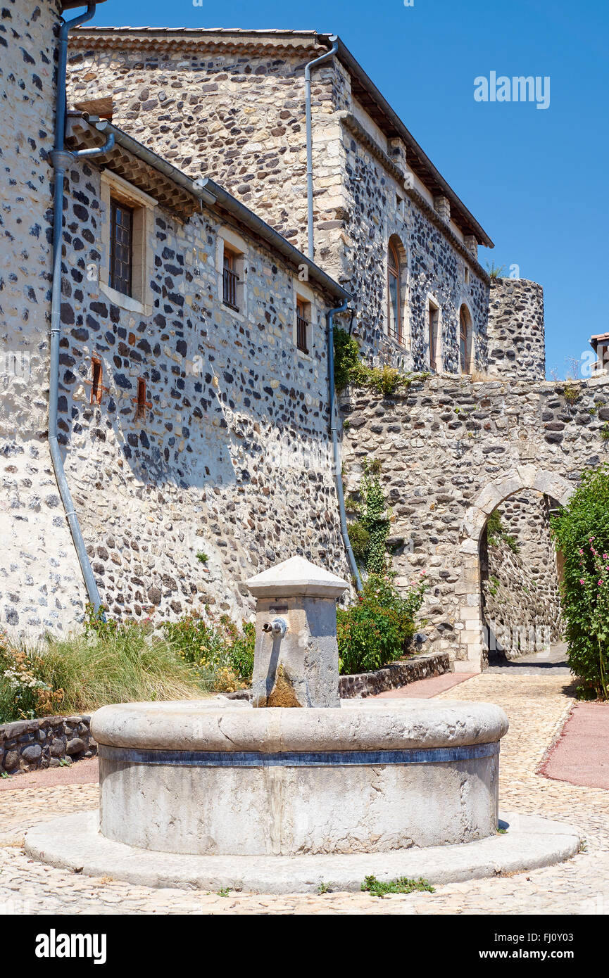 A stone well and medieval buildings in Saint-Vincent-de-Barres in ...