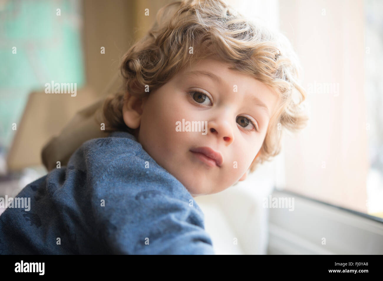 Portrait of little boy looking over his shoulder Stock Photo - Alamy
