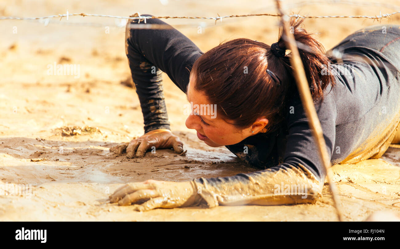 Participant in extreme obstacle race crawling under barbed wire Stock ...
