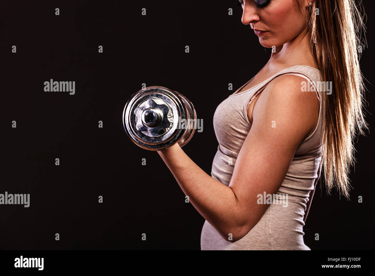 Bodybuilding. Strong fit woman exercising with dumbbells. Closeup ...