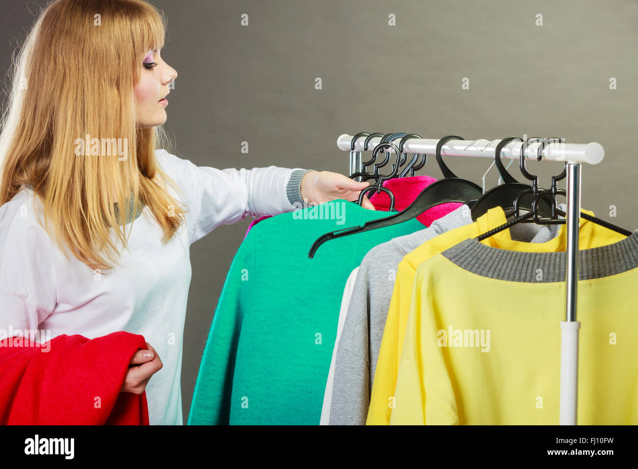 Pretty happy woman watching clothing from new collection wardrobe ...