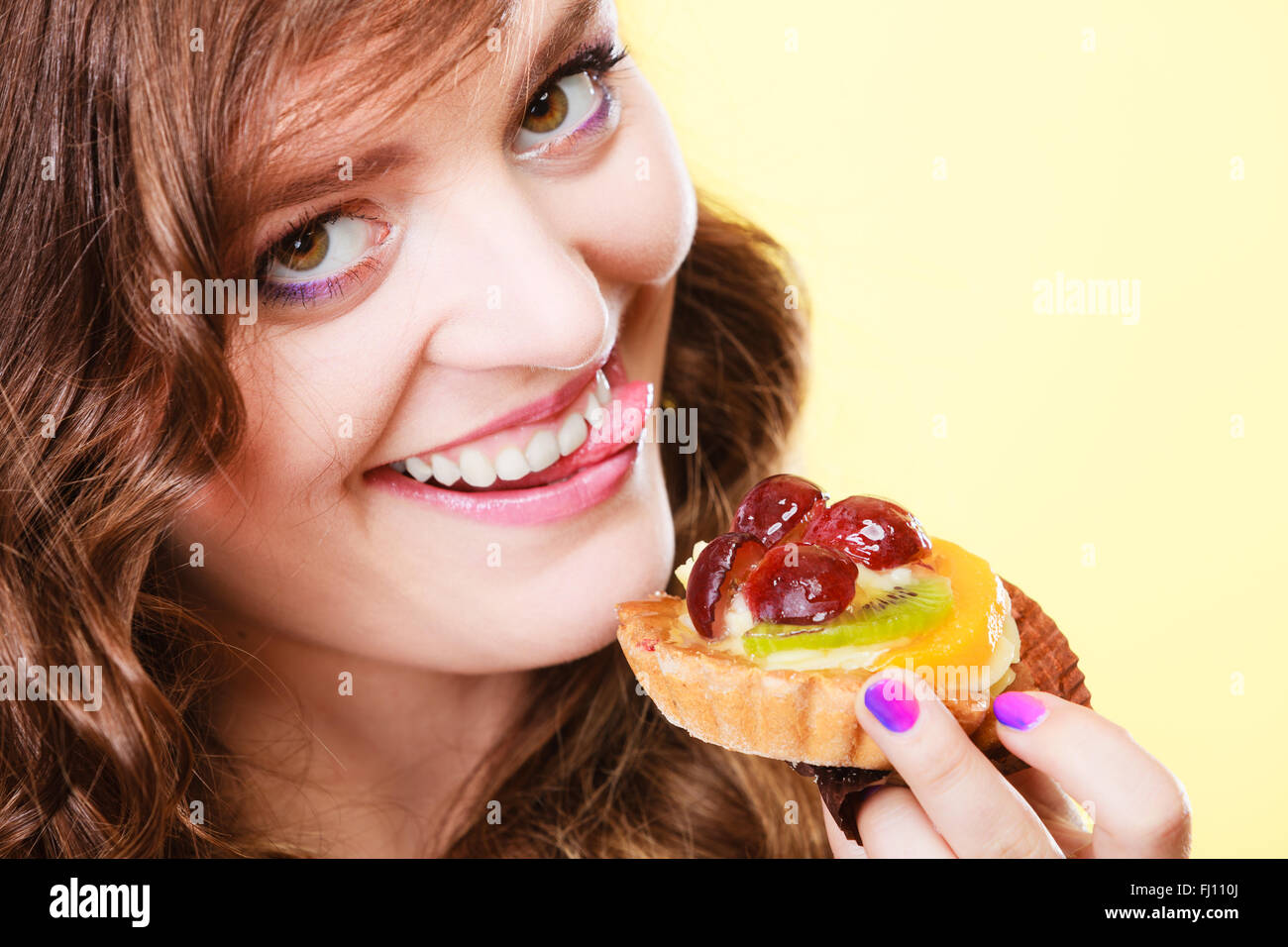 Sweetness and happiness concept. Closeup cute funny woman eating fruit ...
