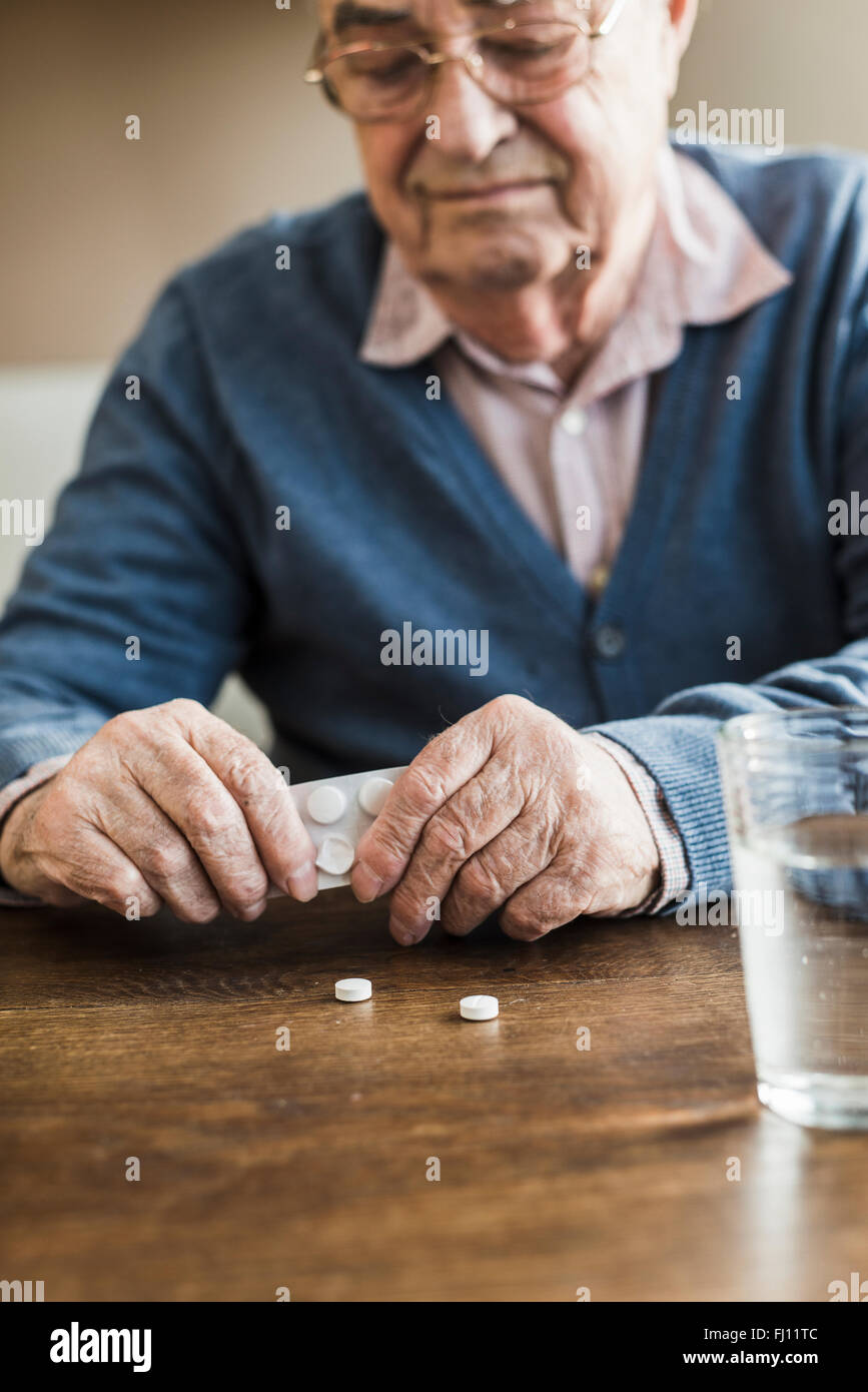 Senior man taking tablets out of blister pack, close-up Stock Photo - Alamy