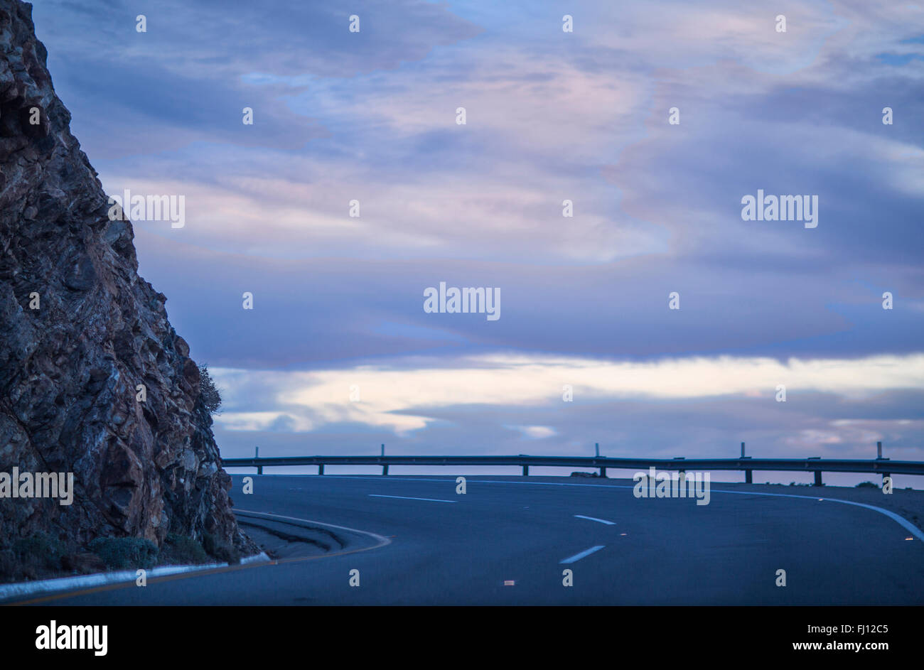 Road beside the cliff is dangerous. The tender blue sky gives dangerous ...