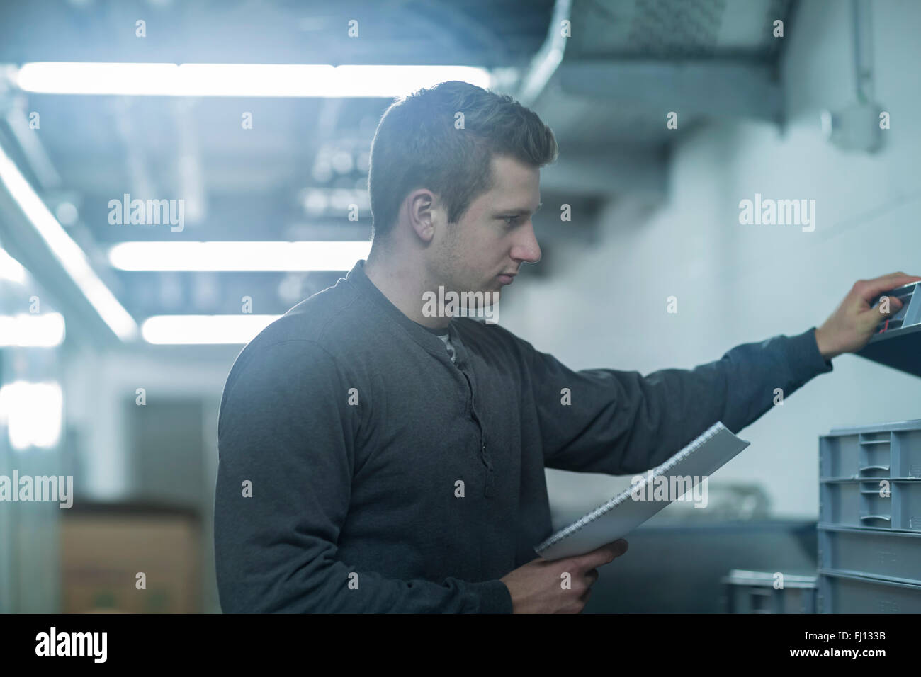 Young man working in technical room Stock Photo - Alamy