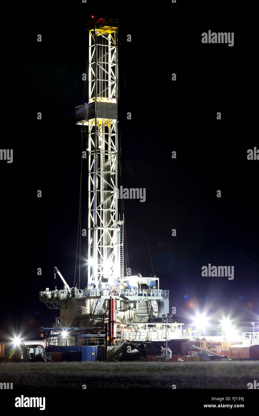 A well drilling rig works in the eastern plains of Colorado to reach ...