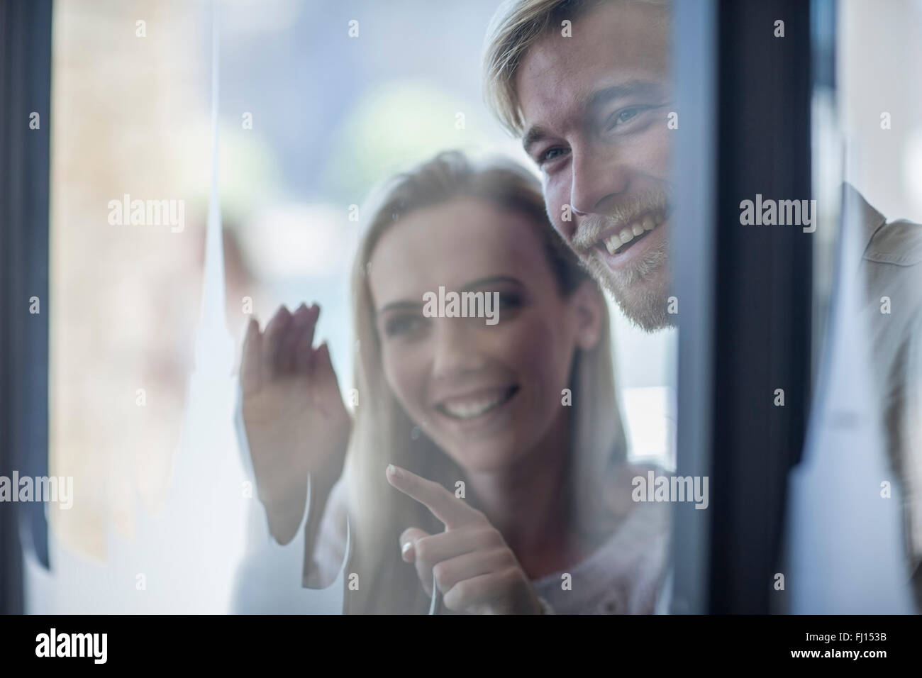 Young couple looking through shop window Stock Photo - Alamy