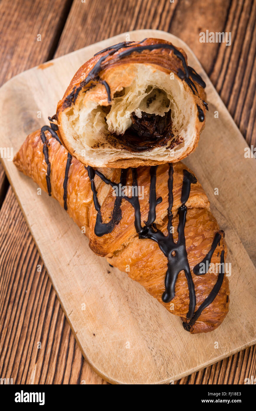 Fresh made Chocolate Croissants (close-up shot) on wooden background ...