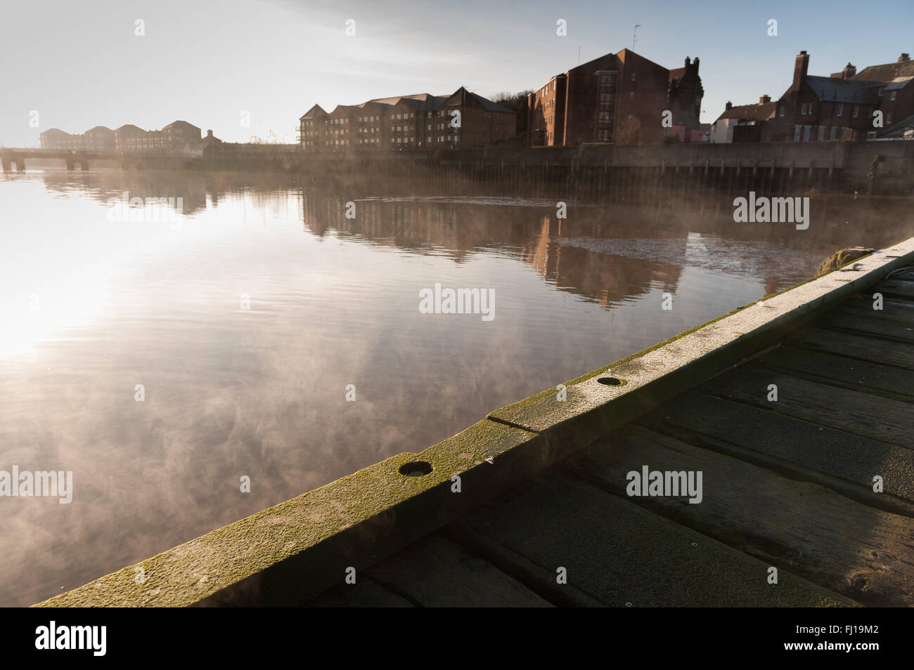 billowing steam evaporating from heated frozen water causeway on river ...