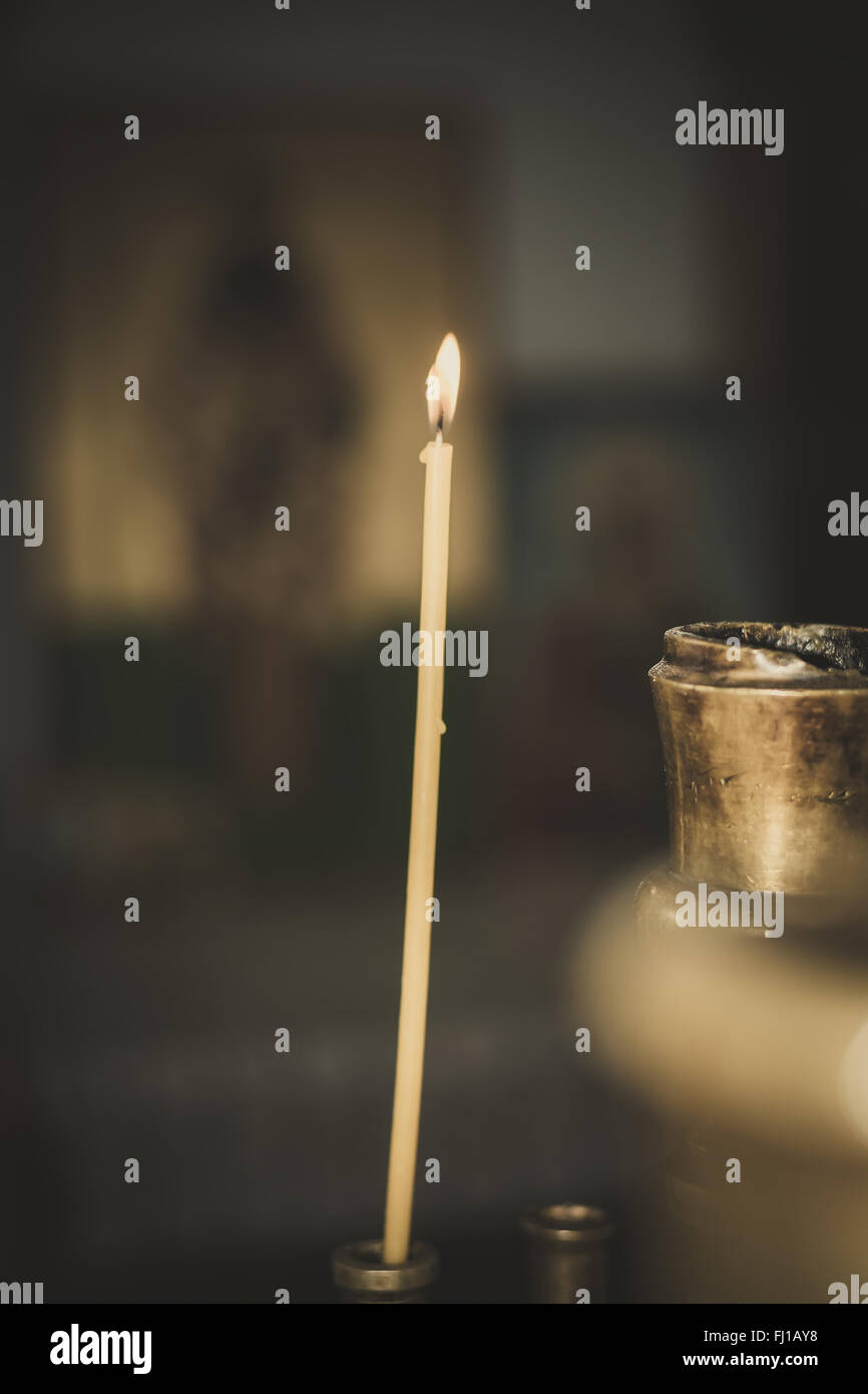 Church burning candle in temple for prayer - soft dramatic Stock Photo ...