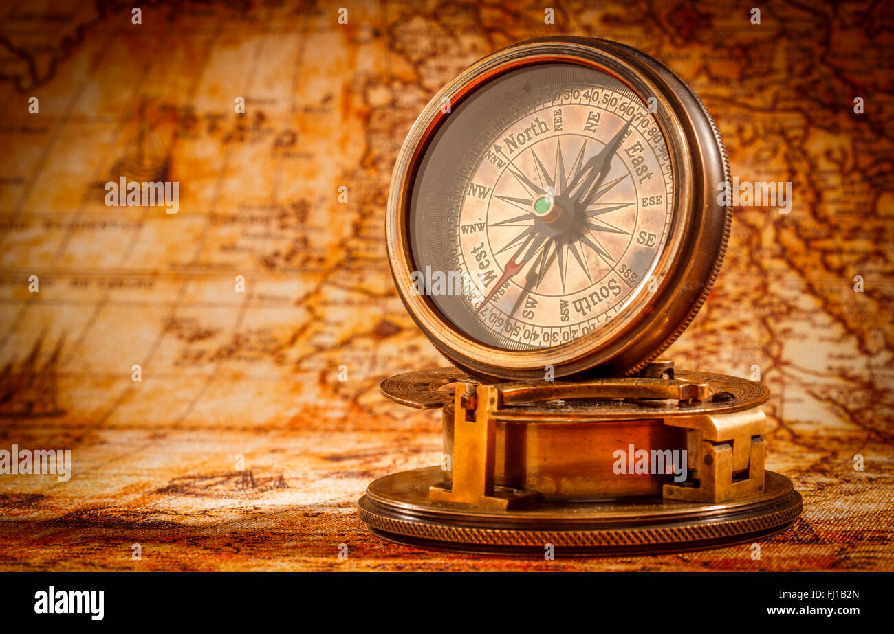Vintage still life. Vintage compass lies on an ancient world map Stock ...