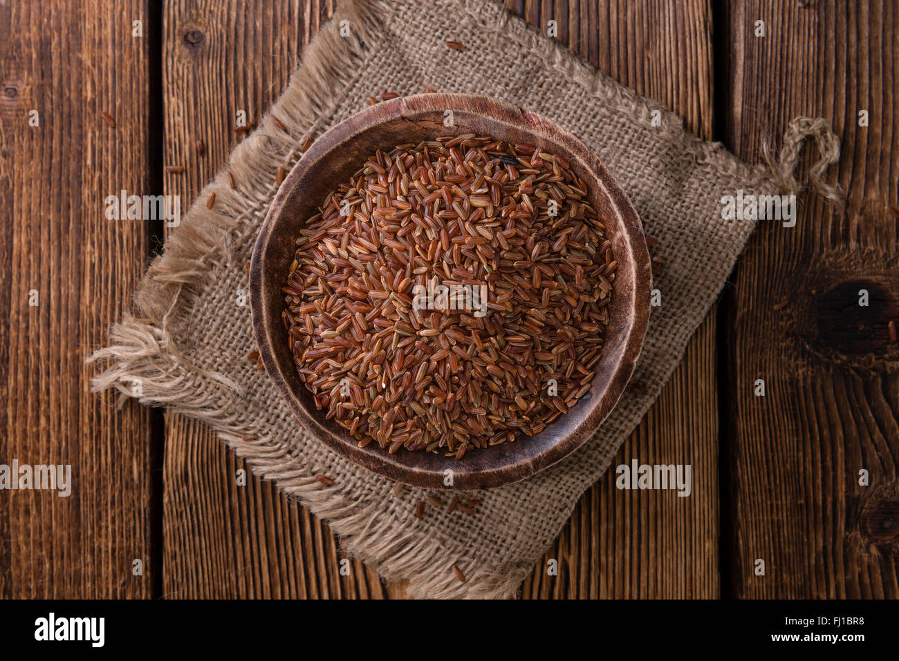 Portion of red Rice (close-up shot) on wooden background Stock Photo ...