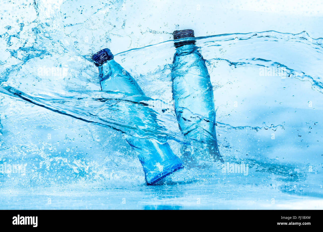 Bottle of water splash on a blue background Stock Photo - Alamy