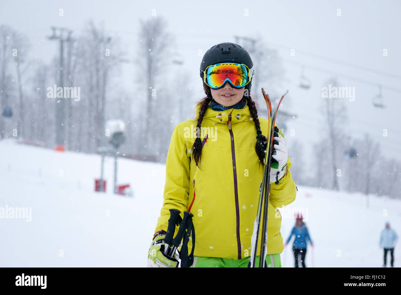 Female skier standing with skies in one hand on background beautiful ...